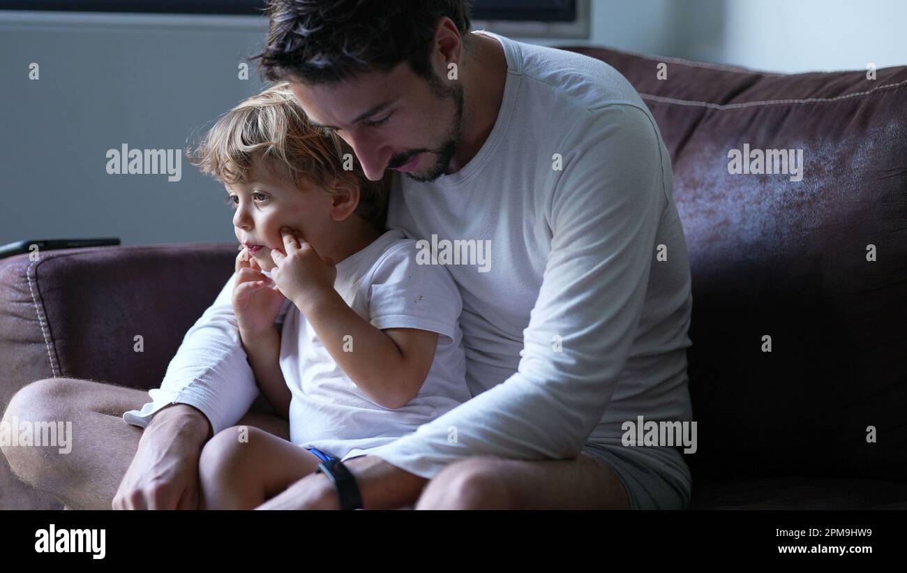Playful dad and son relationship. Child seated on father lap on couch ...