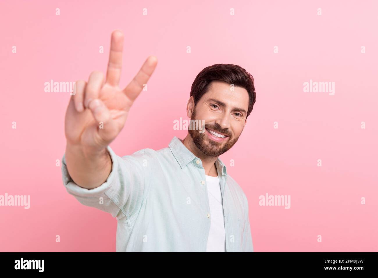 Closeup portrait of smiling happiness handsome guy show fingers v-sign ...
