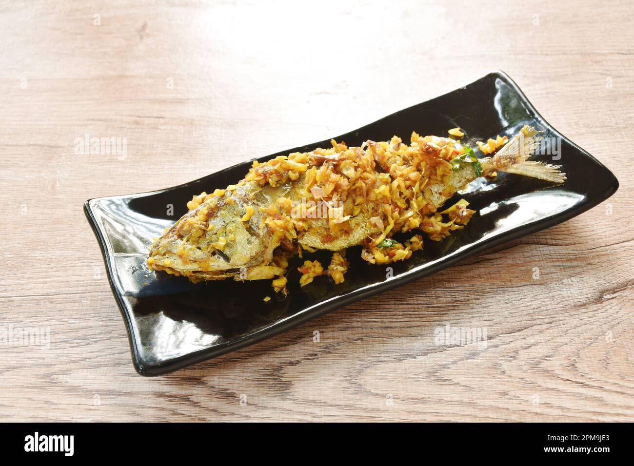 deep fried mackerel fish with turmeric dressing chili and garlic on ...