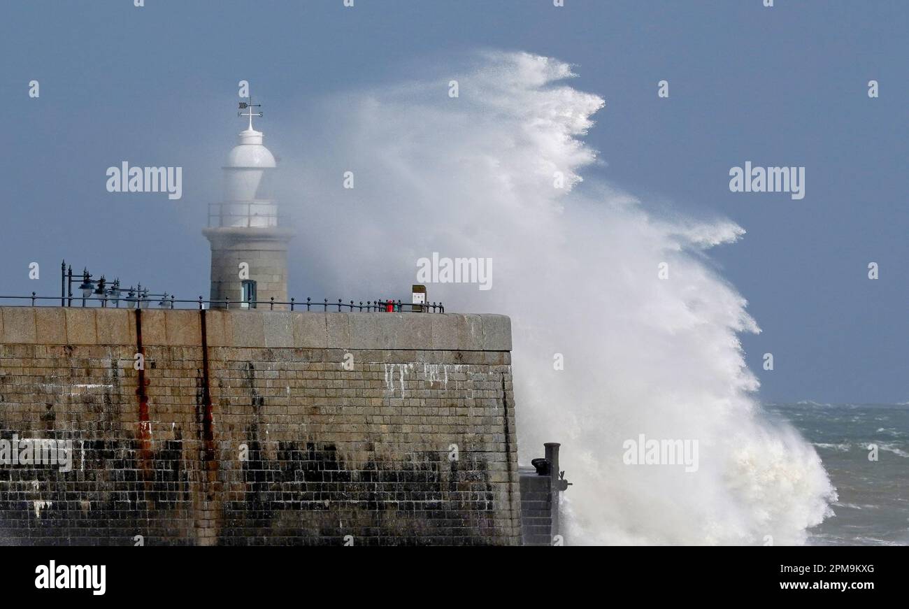 Waves crash around the lighthouse on the harbour arm in Folkestone ...