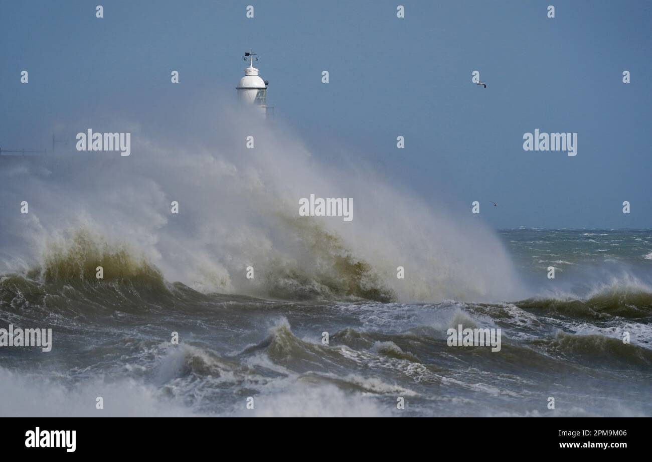 Waves crash around the lighthouse on the harbour arm in Folkestone ...