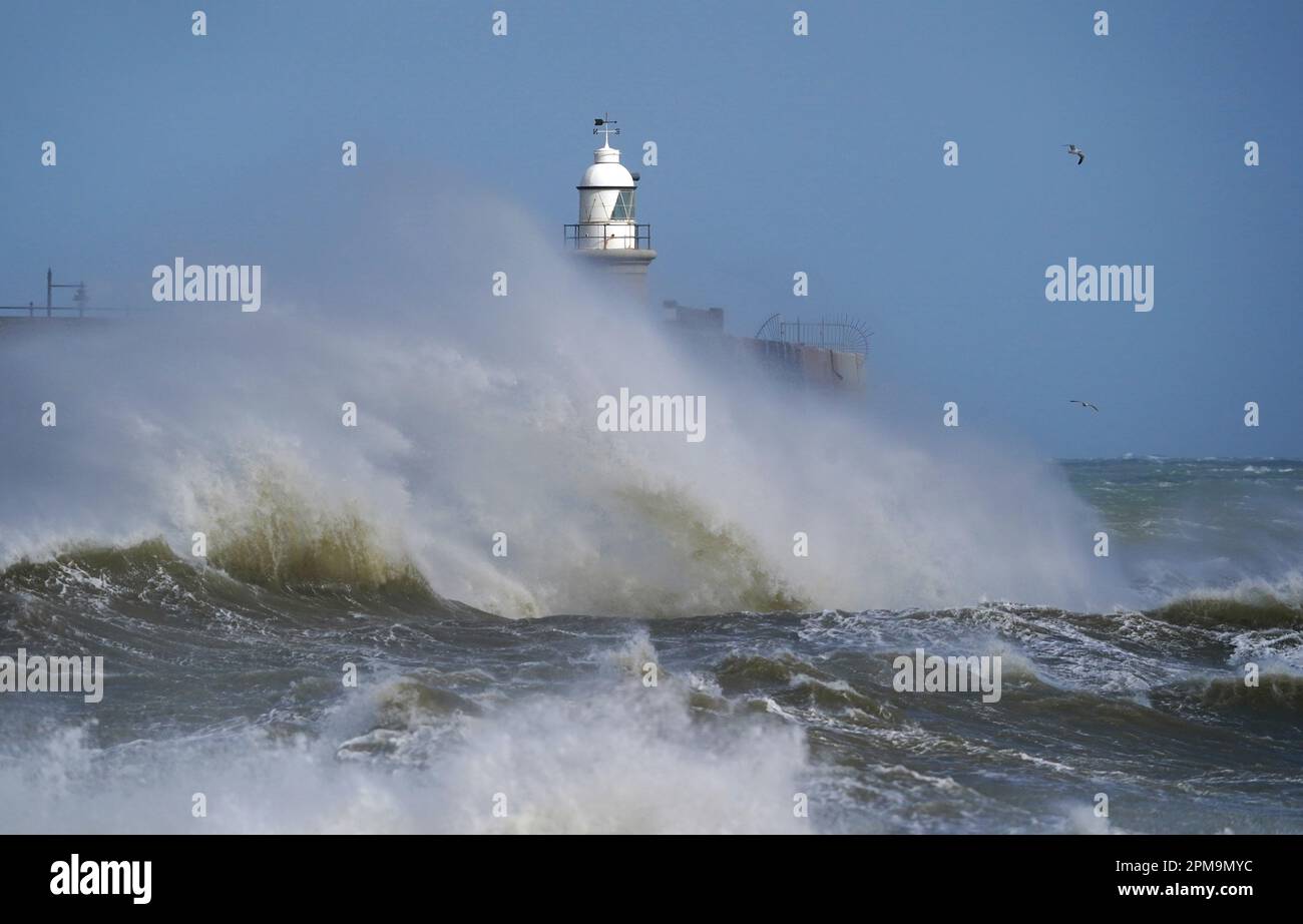 Waves crash around the lighthouse on the harbour arm in Folkestone ...