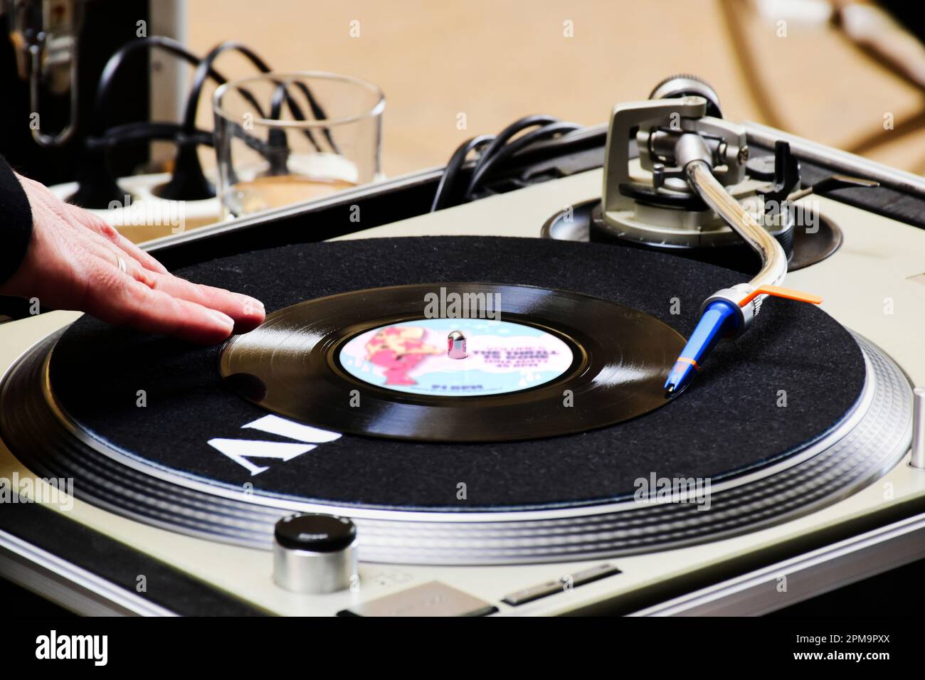 turntable closeup view with male dj hand spinning. silver metal color ...