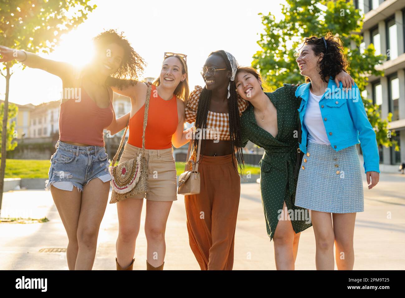 Five young girls walking around the city, multiracial group of female ...