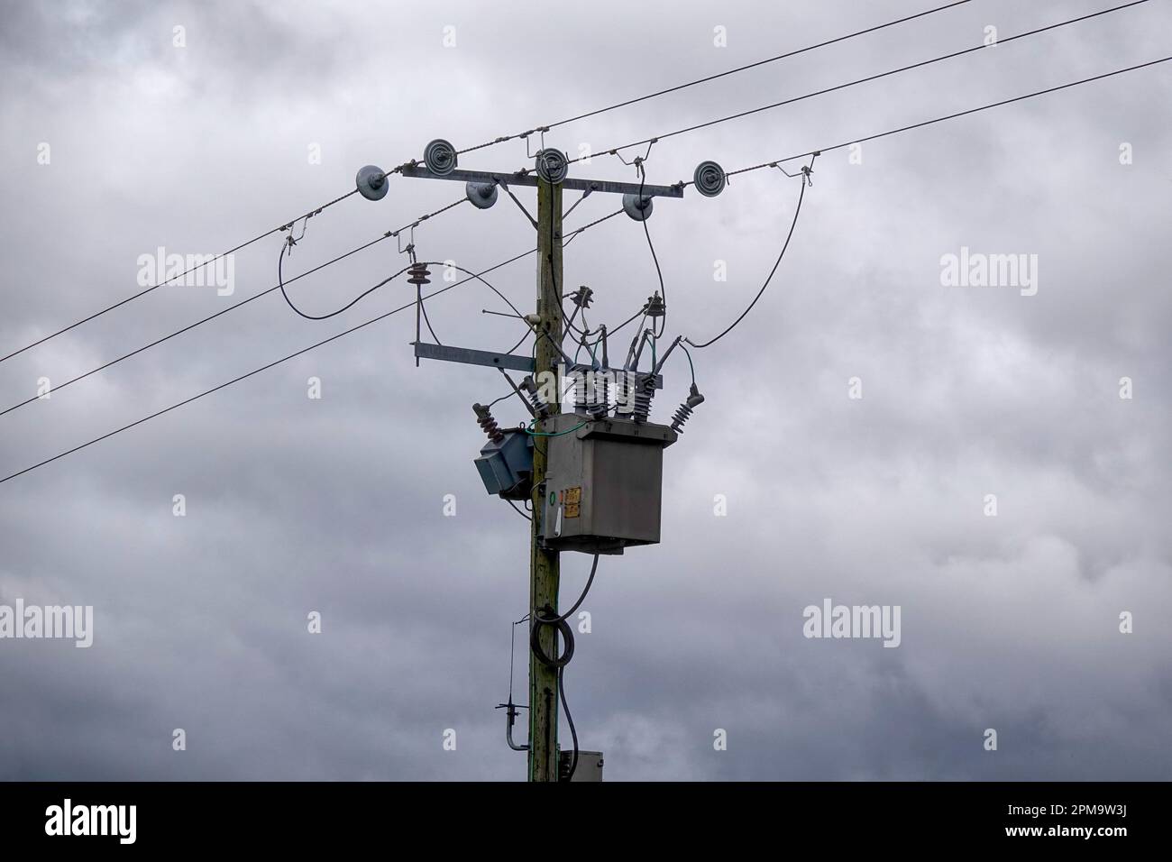 An electric power transformer mounted on wooden poles in the UK ...