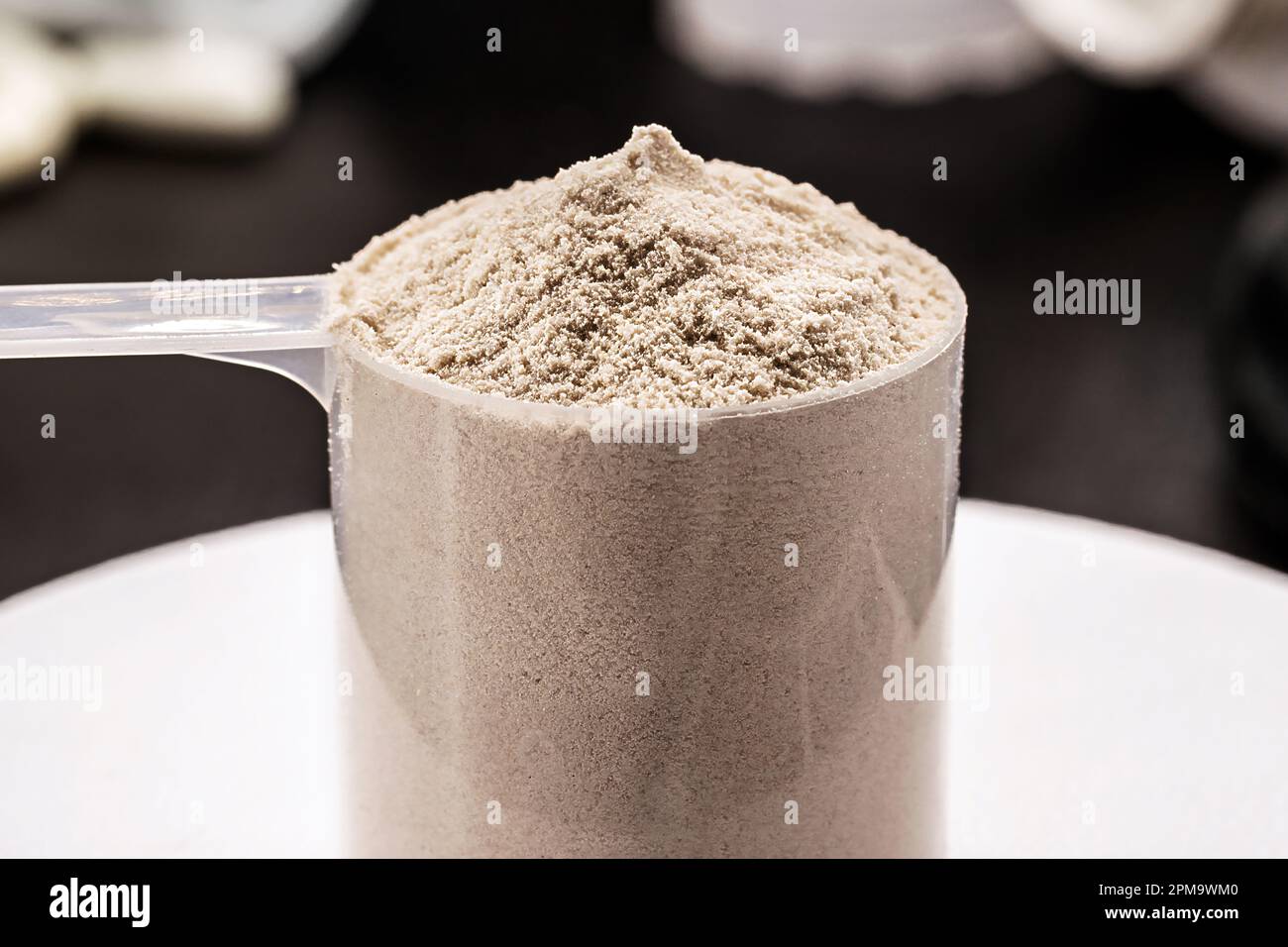 Measuring spoon with creatine or whey, on precision scale, preparing ...