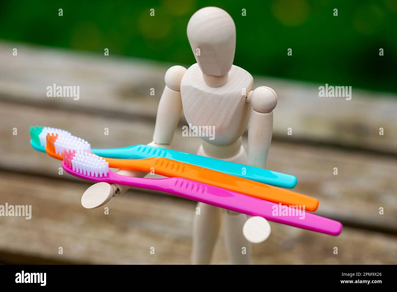 Multi-colored toothbrushes in the hands of a human figure. Cleaning and ...