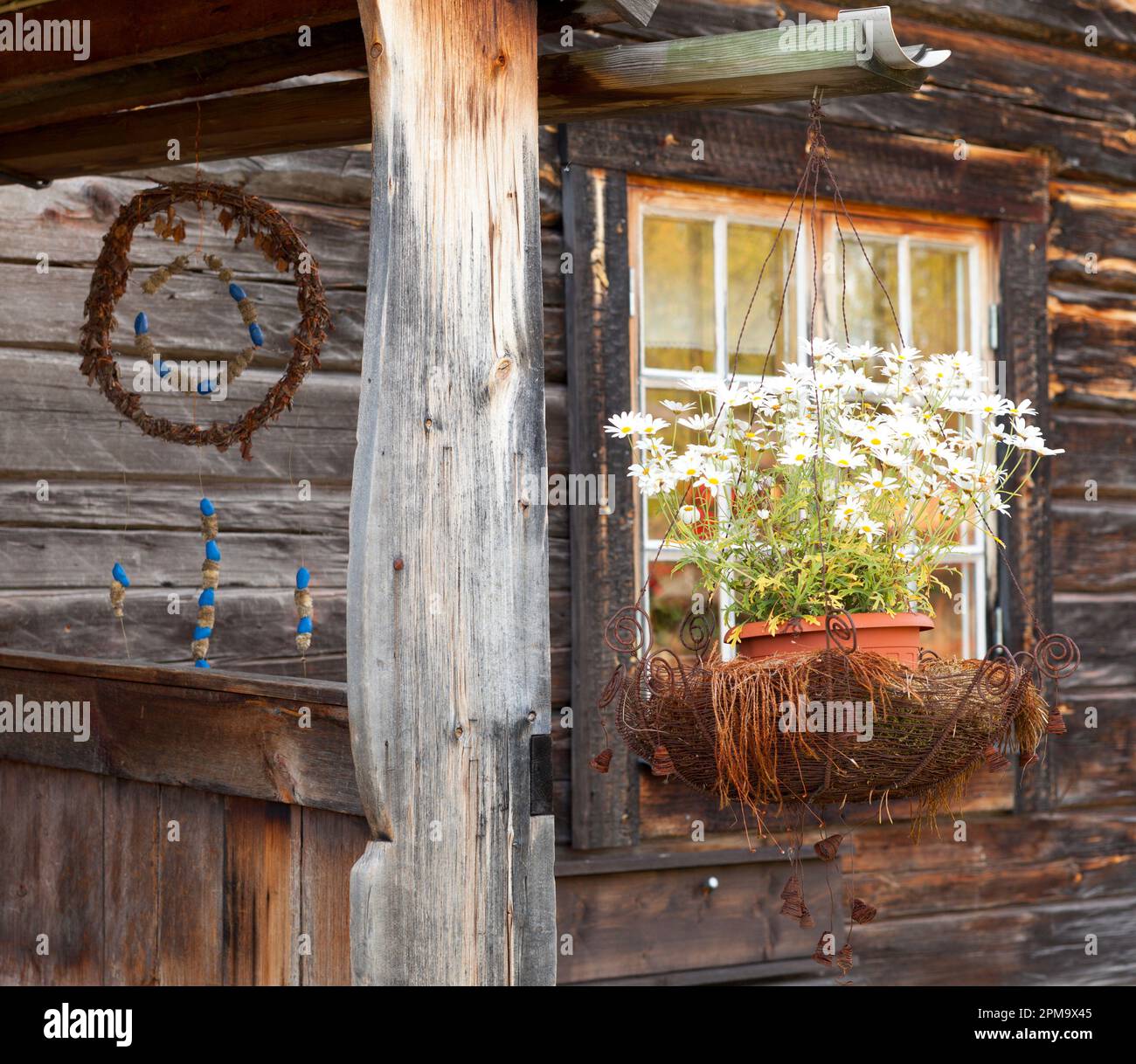 Wooden walls and windows at an ancient building. Flower, flower-pot ...