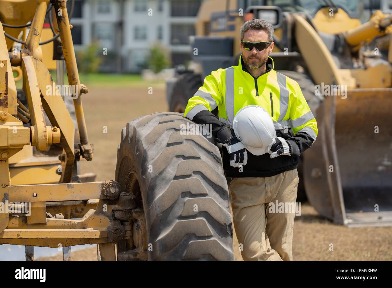 Machinery builder at buildings background. Excavator loader tractor and ...