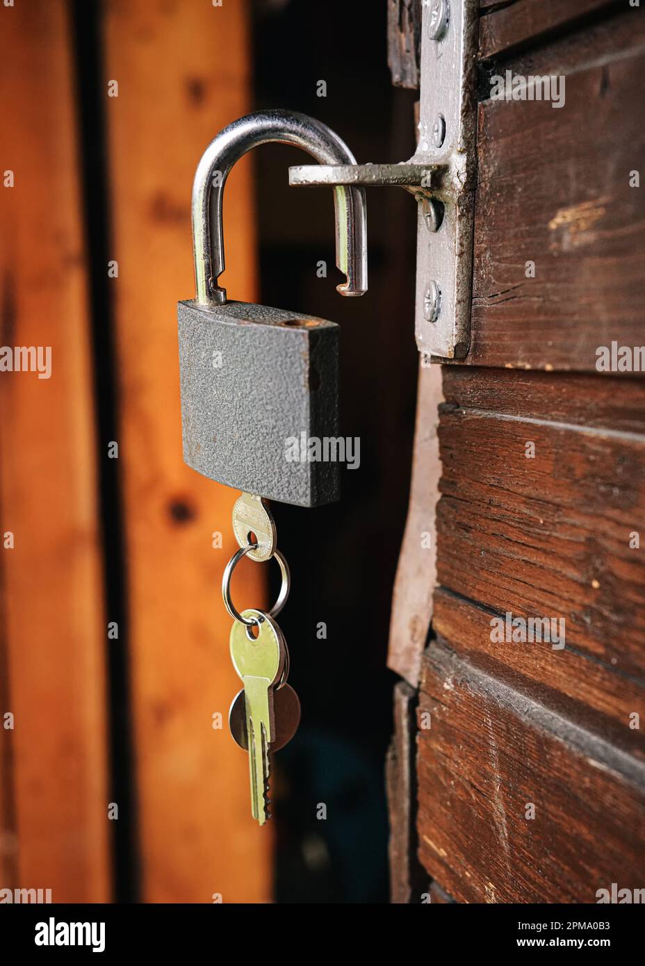 Classic metal padlock hanging at old wooden cottage, keys inside ...