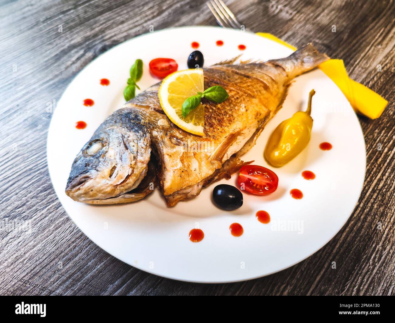 Golden fried sea bream fish on plate with vegetables, top view Stock ...