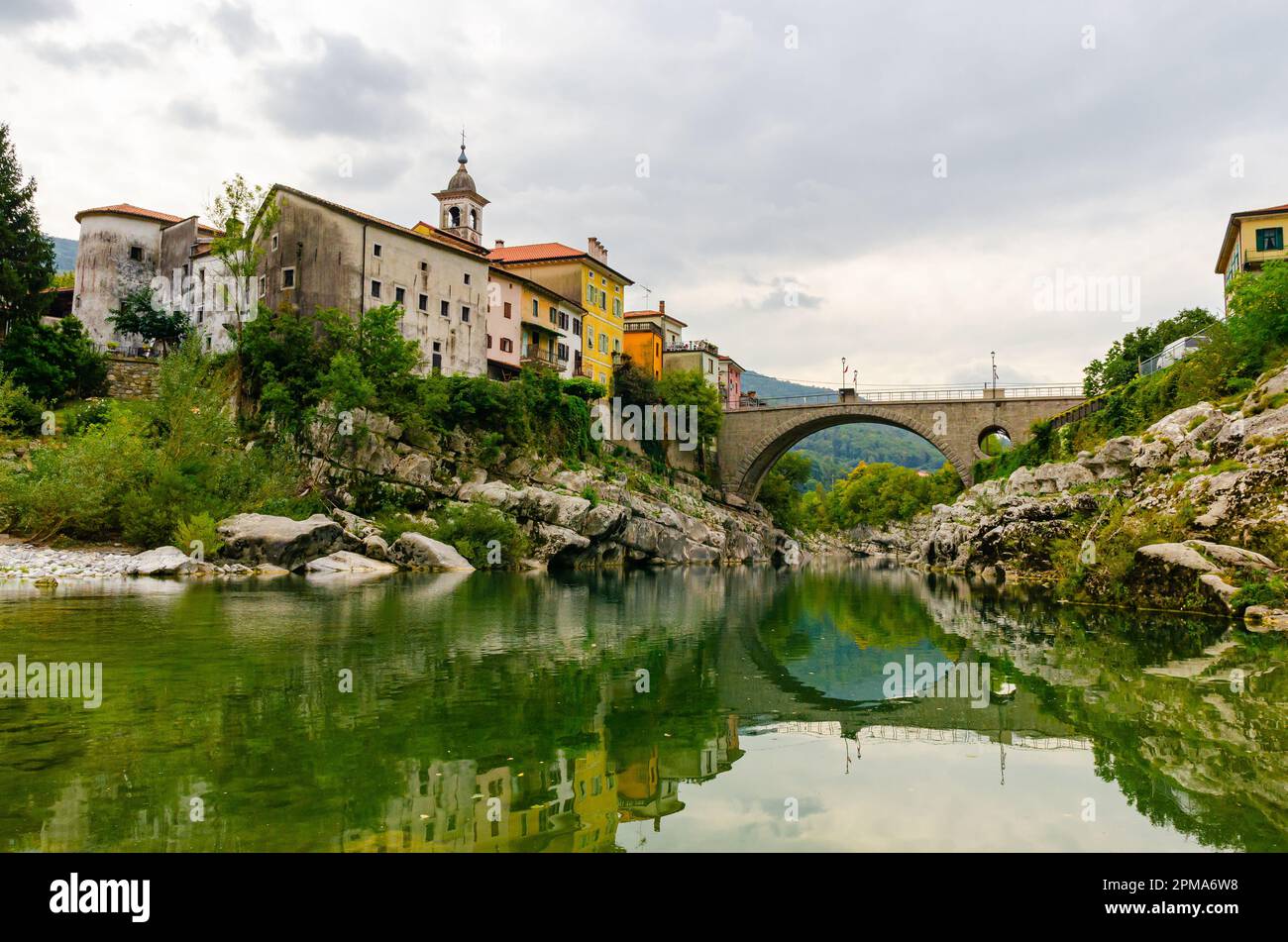 River Soca in Slovenia - Kanal ob Soci city with a beautiful old stone arch bridge and ...