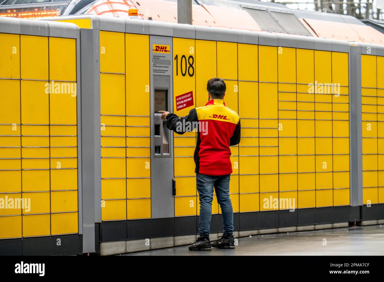 DHL Parcel Station, DHL employee operates the Parcel Pick-up and ...