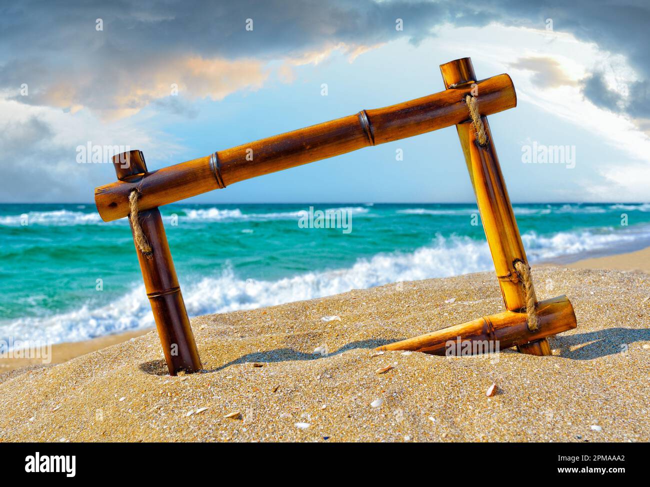 Summer landscape with a bamboo photo frame on the beach sand of a ...
