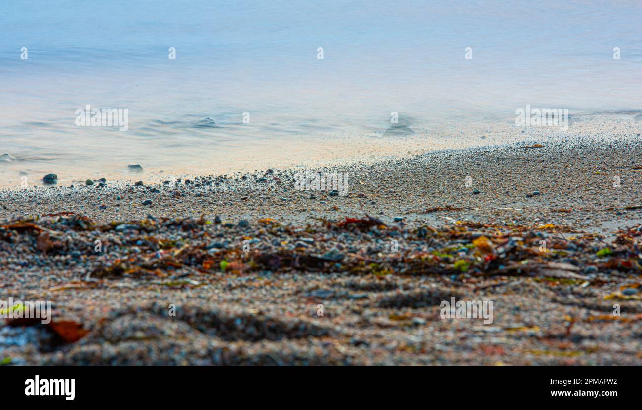 Long exposure photo of sand, rocks and water at a beach Stock Photo - Alamy