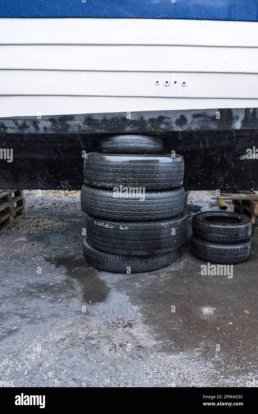 Stack of old tires supporting a boat on land Stock Photo - Alamy