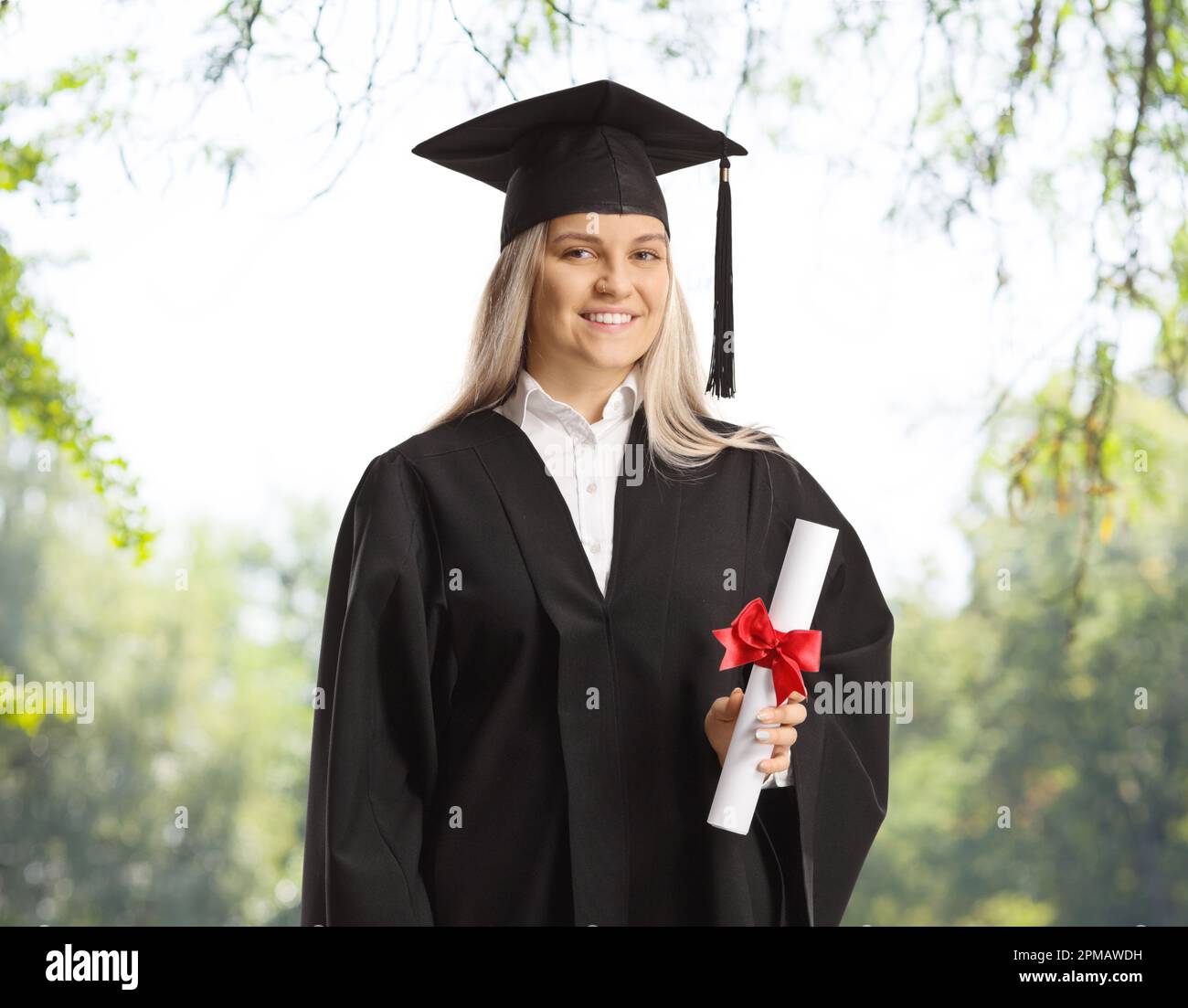 Female graduate student holding a bachelor certificate outdoors with ...