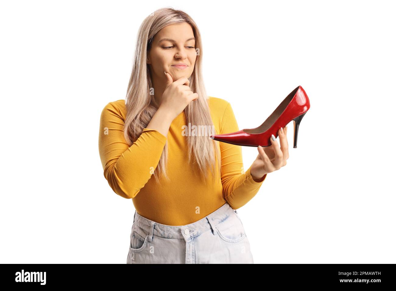 Young woman holding a red high heel shoe and thinking isolated on white ...