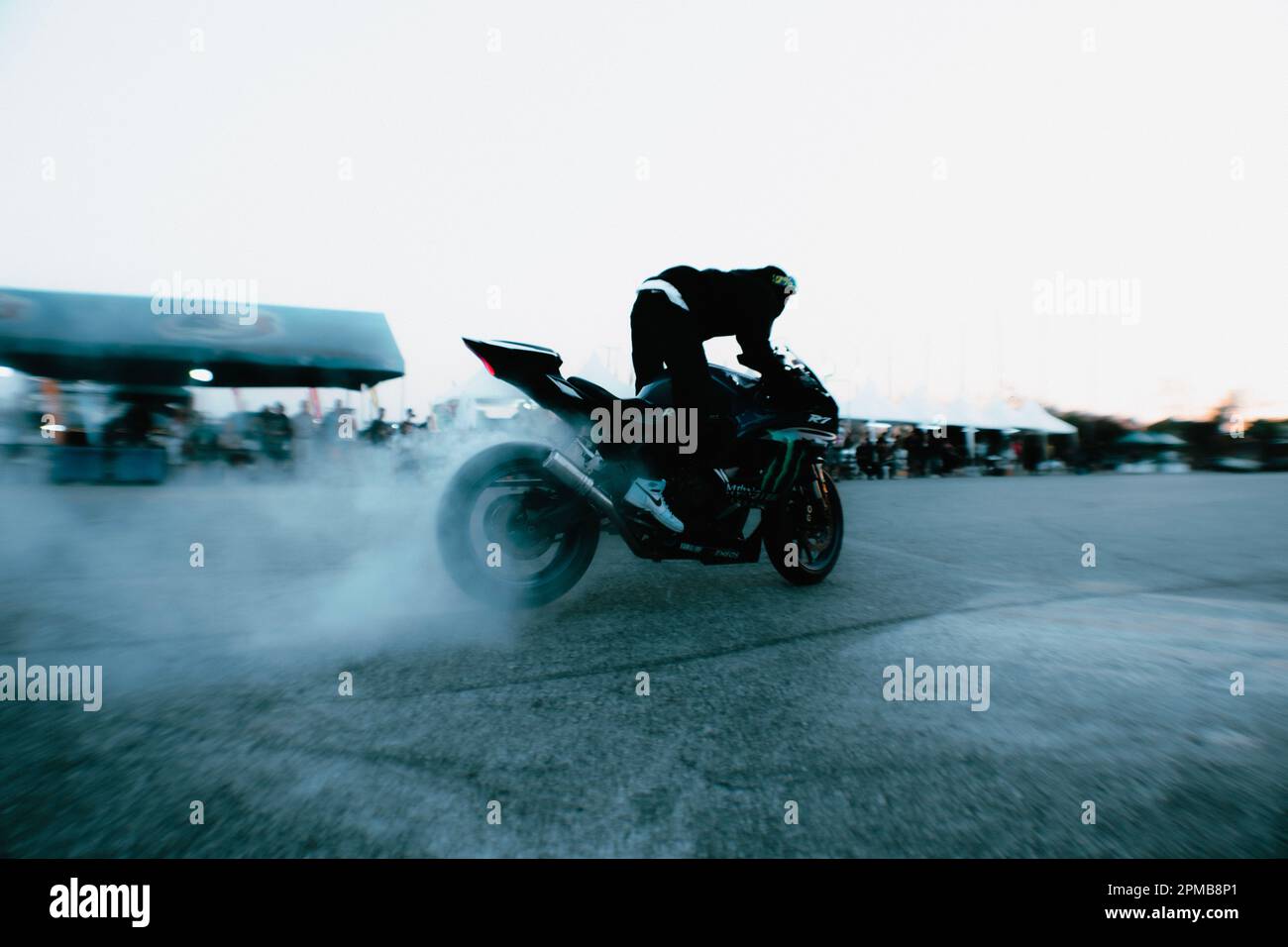Motorcycle stuntman back wheel stand Stock Photo - Alamy