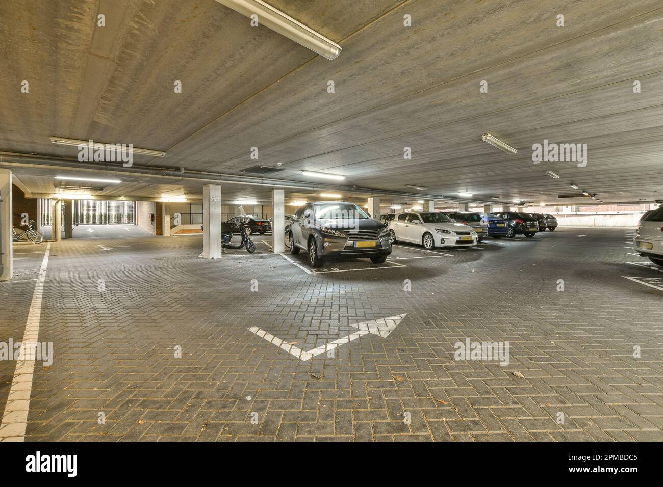 an underground parking area with cars parked in the garages and people ...