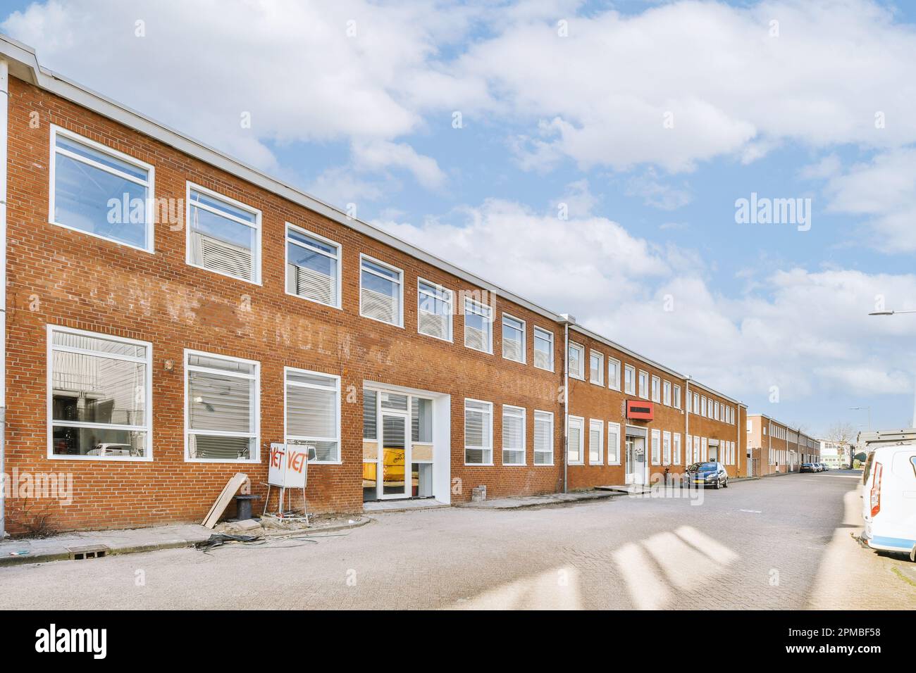 a brick building on the side of a road with cars parked in front and ...