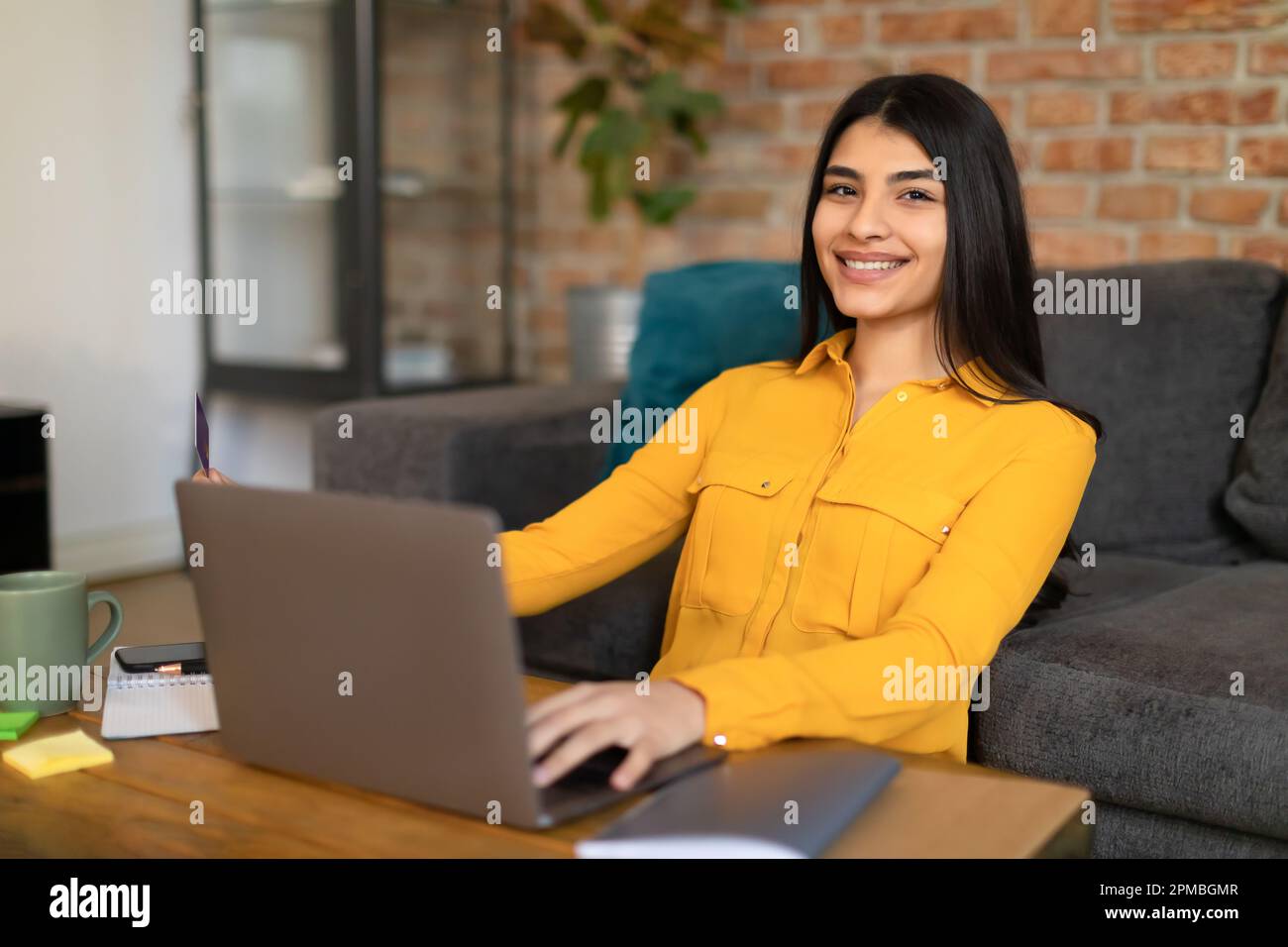 Distance learning. Happy spanish lady using laptop computer, smiling at ...