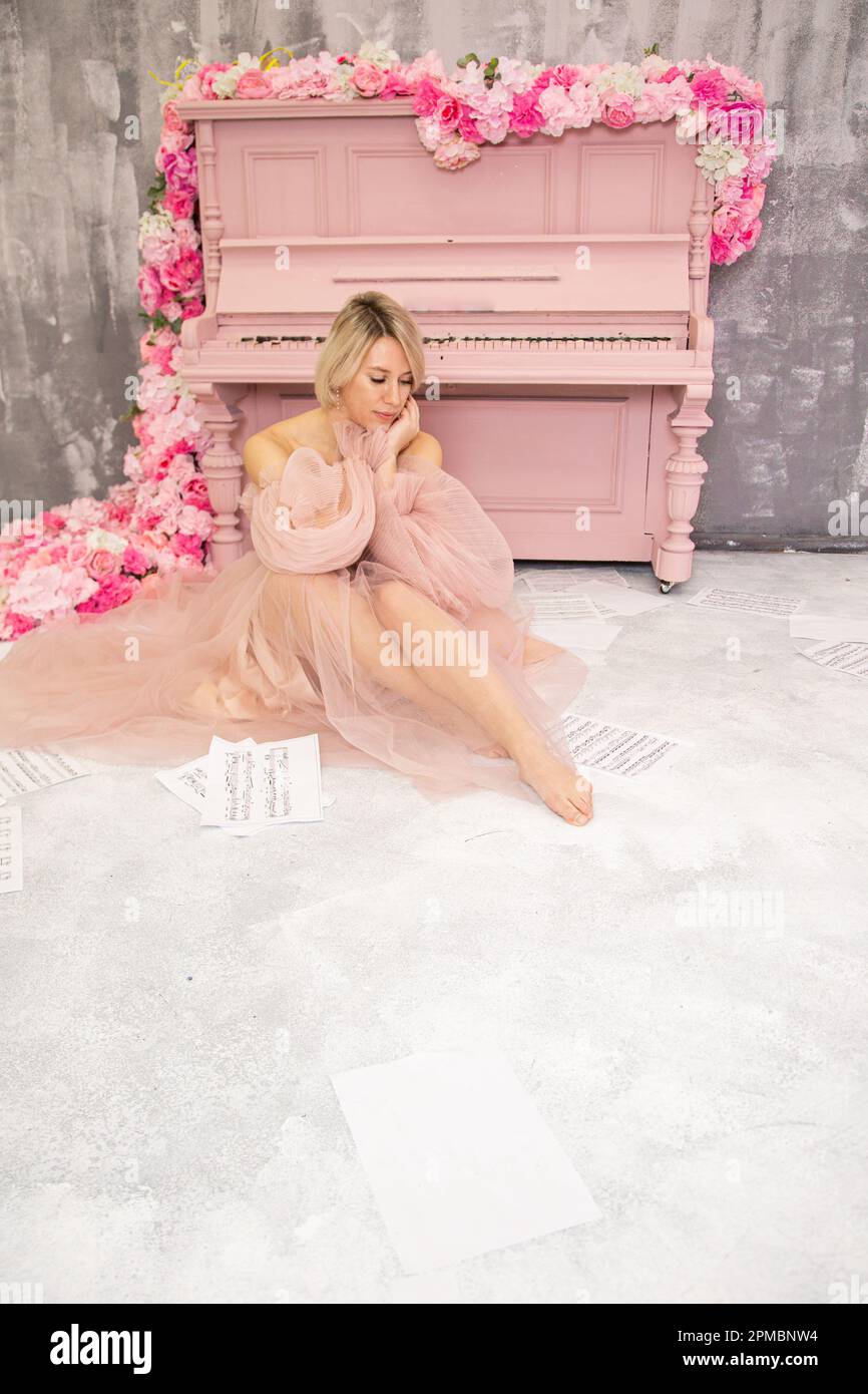 Beautiful lady in pink dress and pink piano Stock Photo - Alamy
