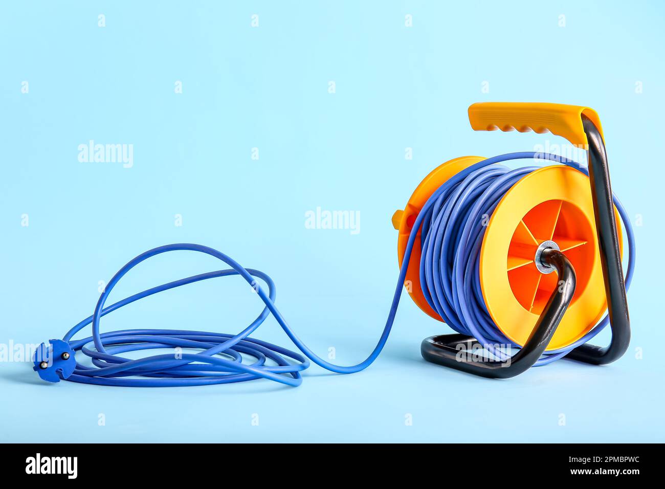 Extension electric cable reel on color background Stock Photo - Alamy