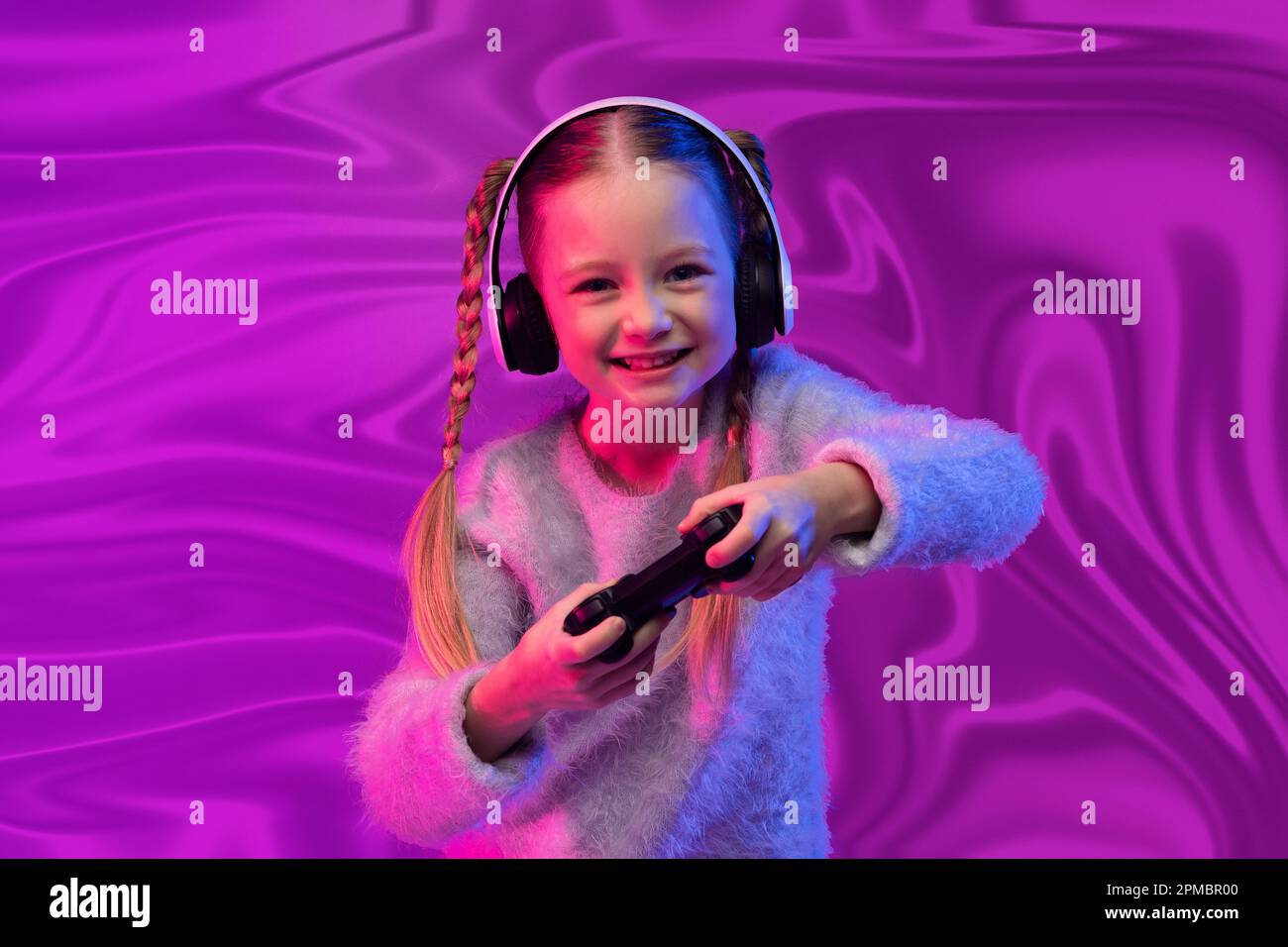 Cheerful kid blondy girl playing video games on abstract background ...