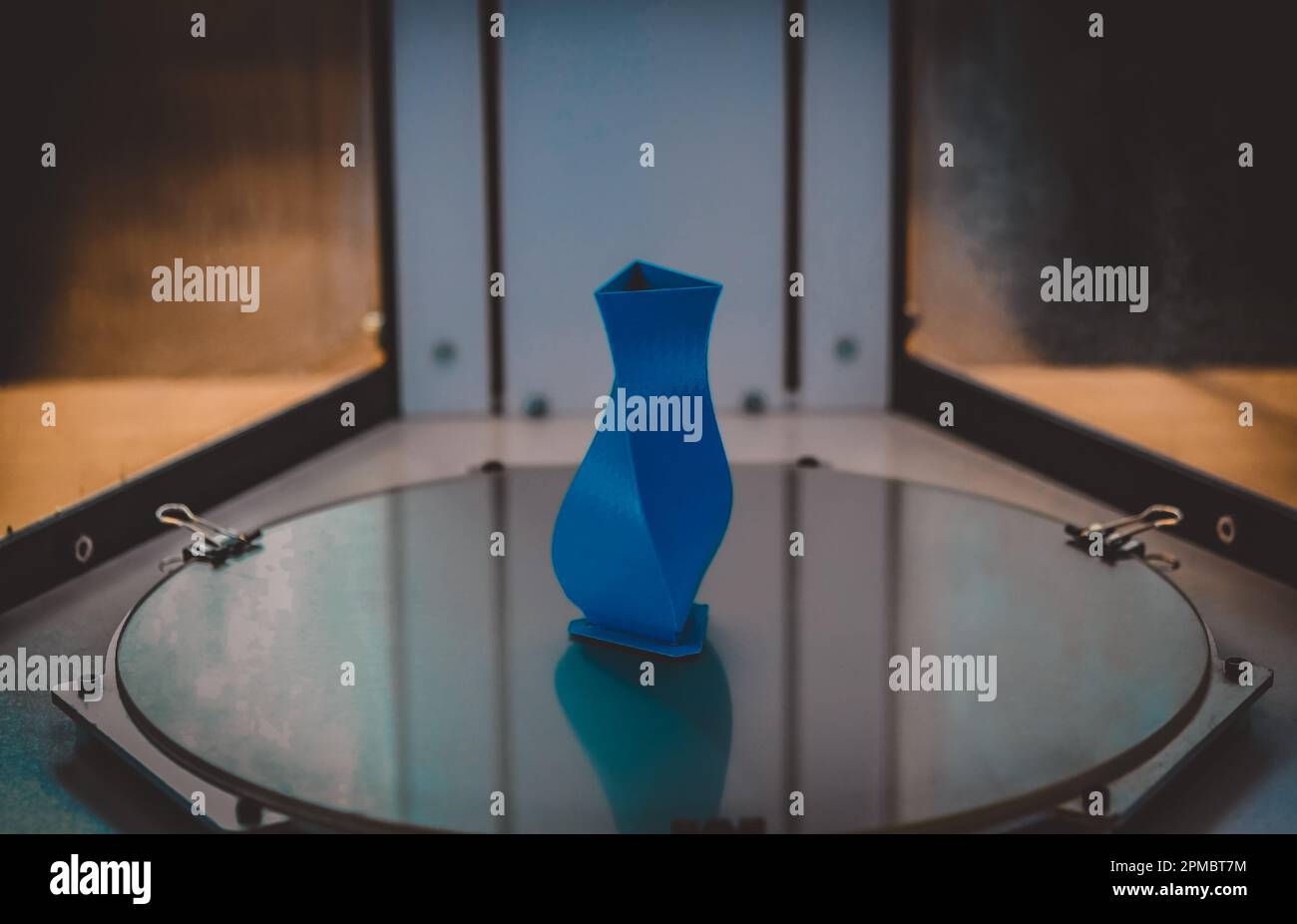 3D printer close up. Bright blue object printed by 3d printer. Modern ...