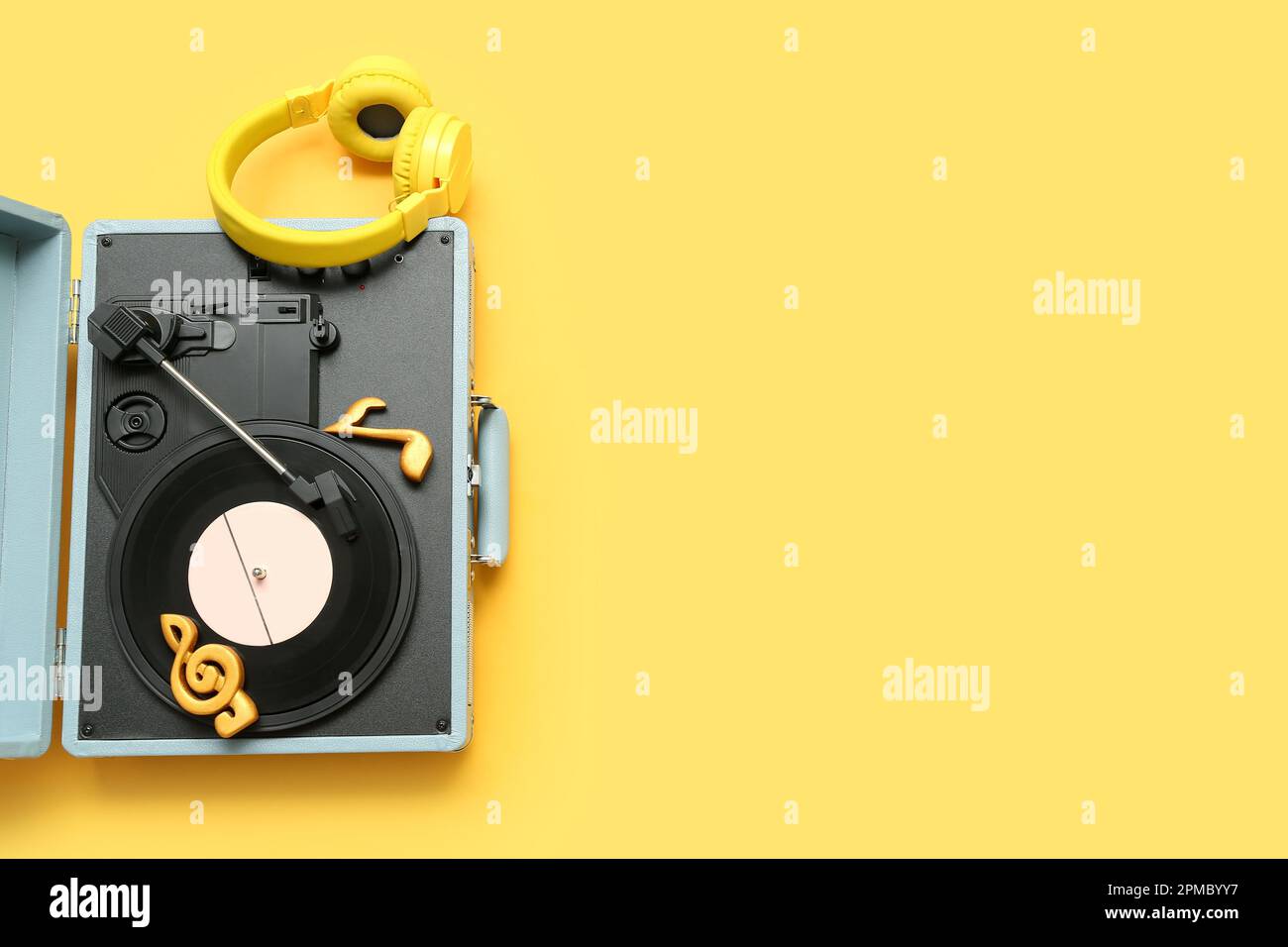 Record player with vinyl disk, note signs and headphones on yellow ...