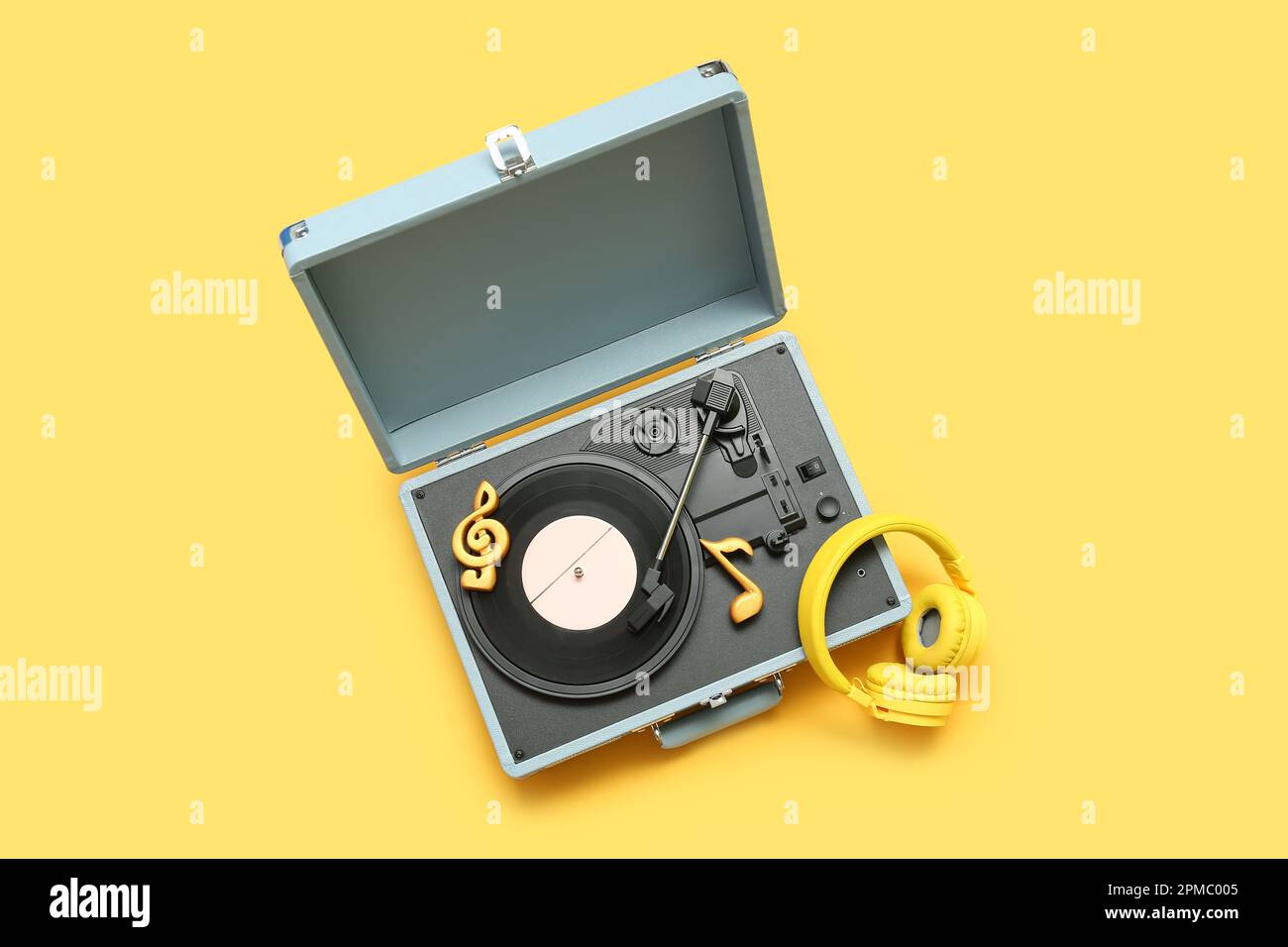 Record player with vinyl disk, note signs and headphones on yellow ...