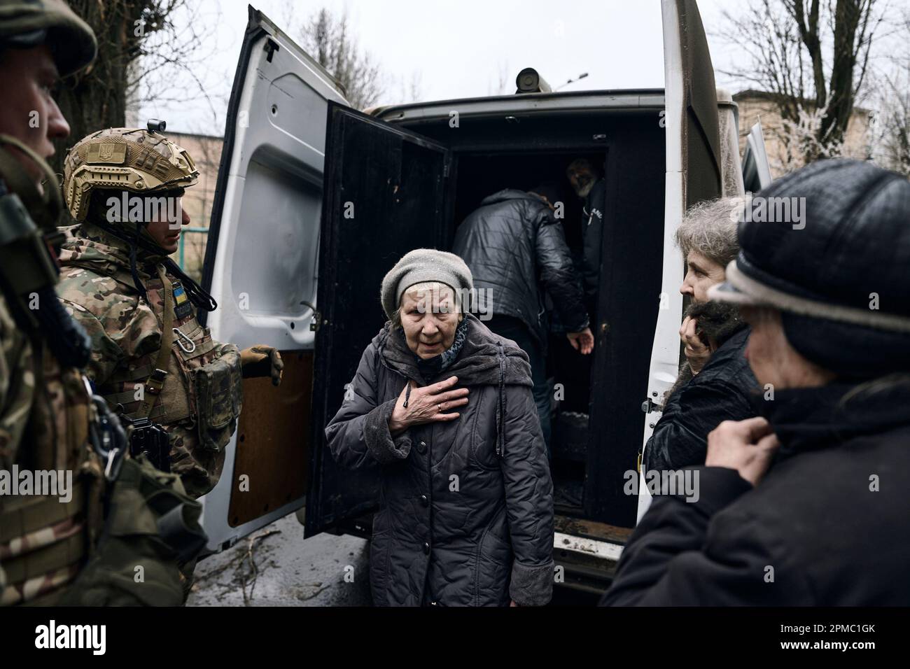A local resident says goodbye to her neighbours as police officers wait ...