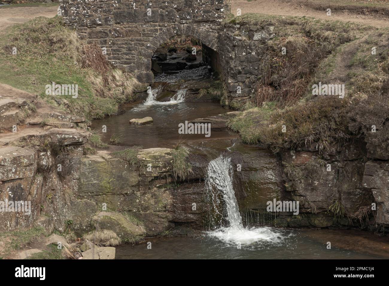 Old stone bridge with waterfall pouring into a pool on a dry day Stock ...