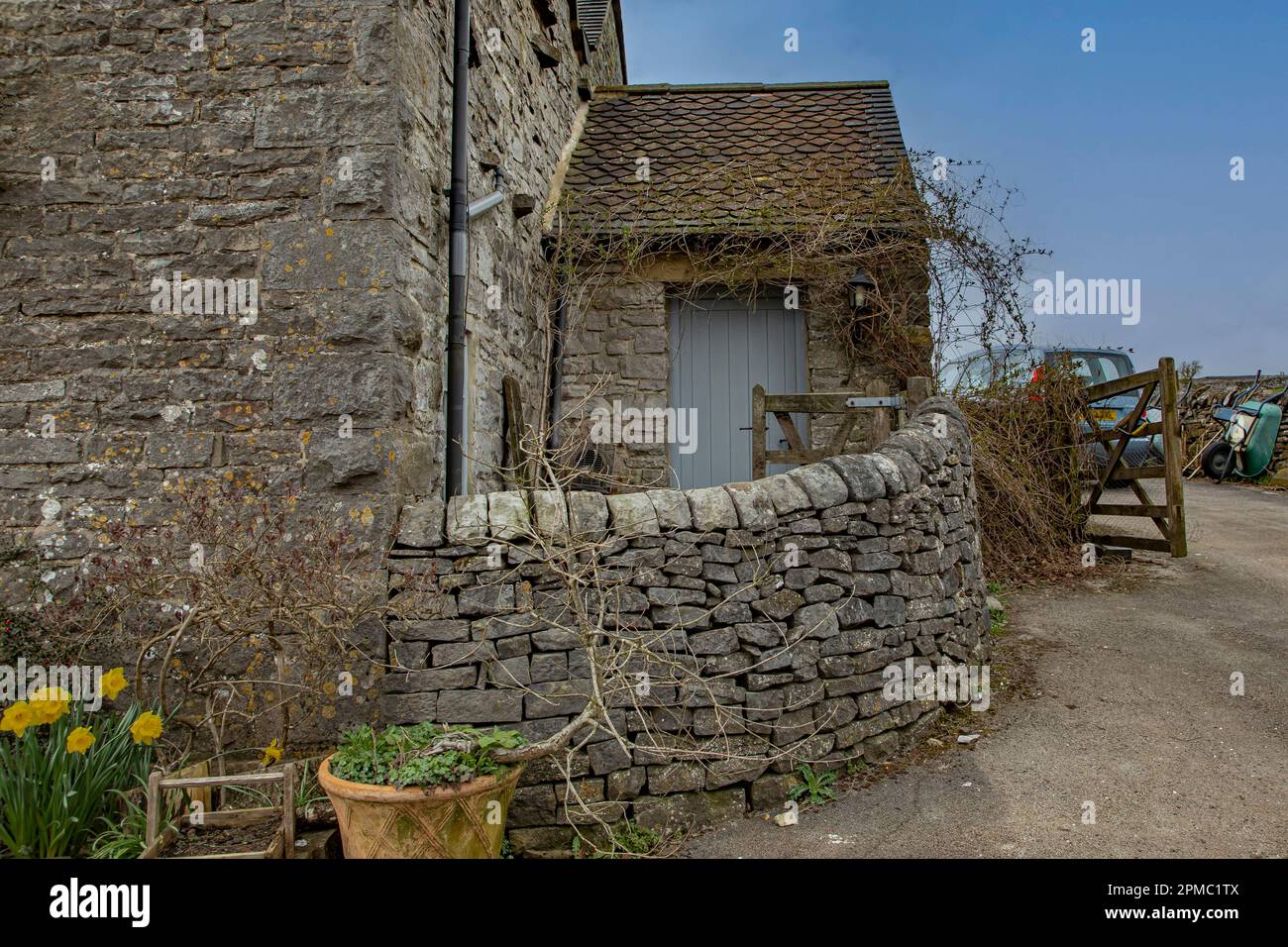 Small side entrance to a house of traditional stone againsta blue sky ...