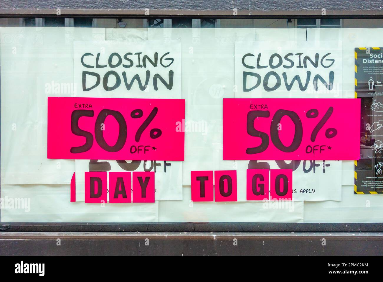 A poster in a shop window advertising 50% discounts as the store is ...