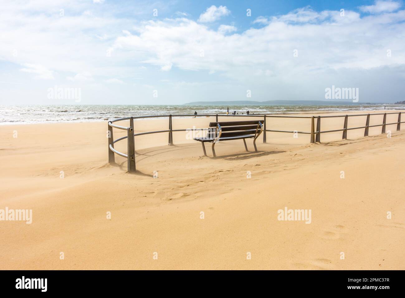 A bench, protected by a semi circle of metal railings looking out to ...