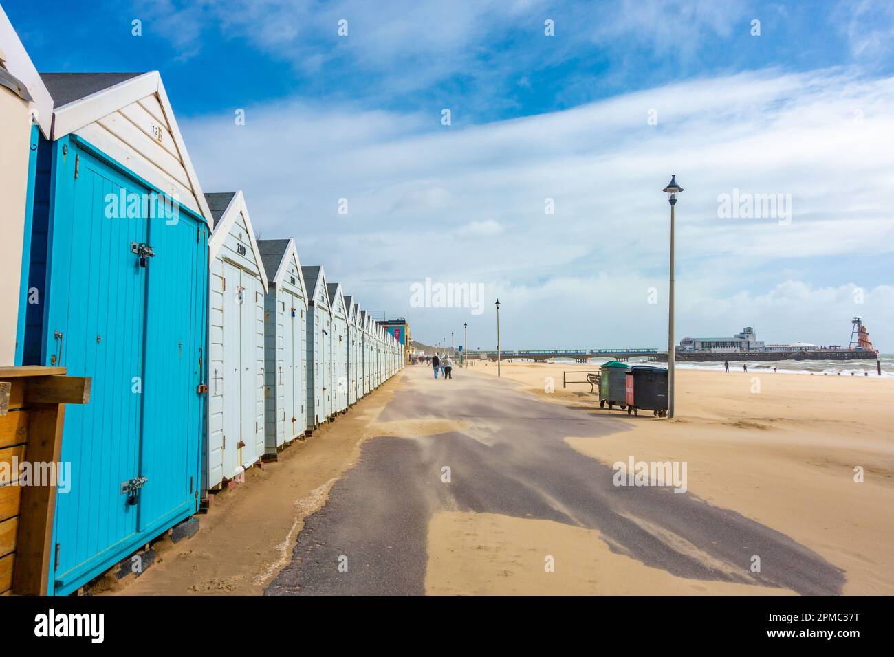 A path in front of beach huts on Bournemouth Beach in Dorset, UK under ...