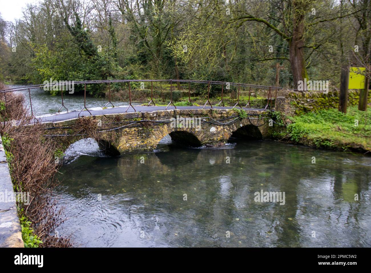 A small stone footbridge spanning the River Coln in Bibury, Gloucestershire, UK Stock Photo - Alamy