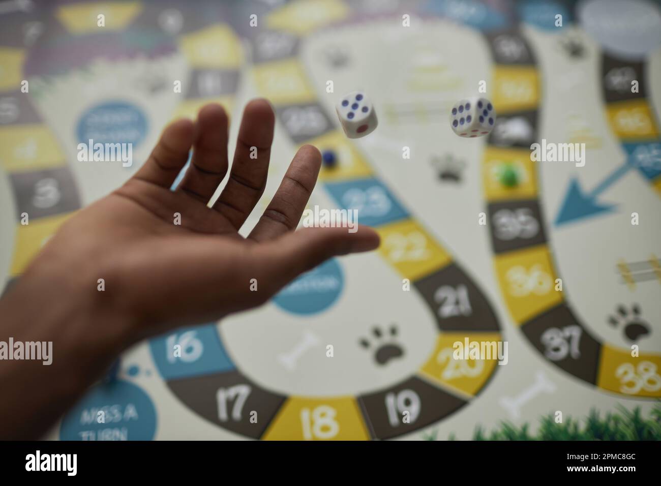 Close up of black male hand throwing dice making a move in board game ...