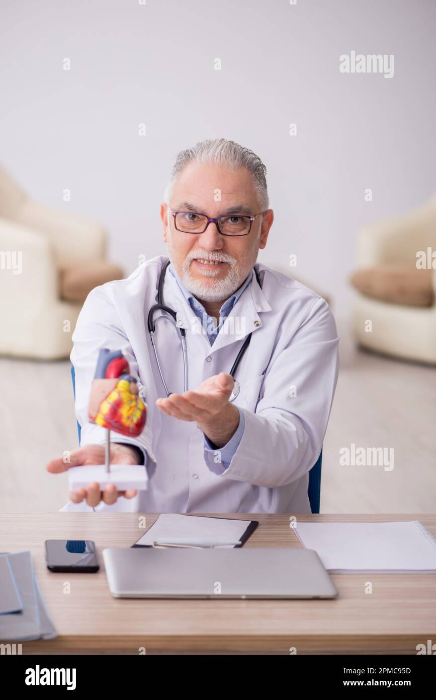 Old doctor cardiologist working in the clinic Stock Photo - Alamy
