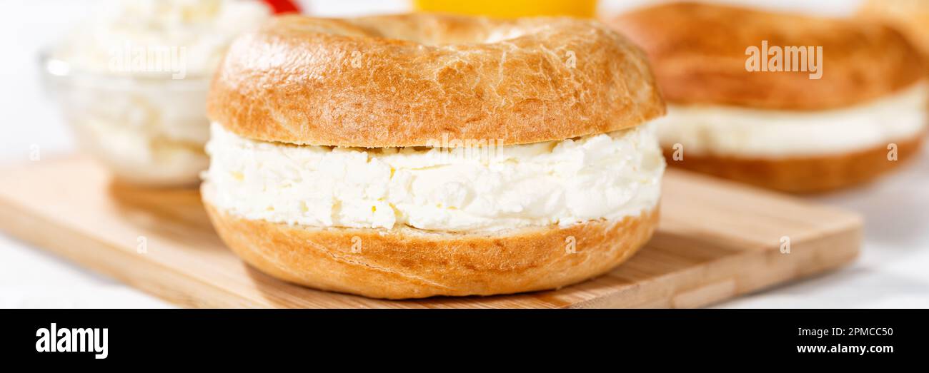 Bagel sandwich with fresh cream cheese for breakfast close up panorama ...
