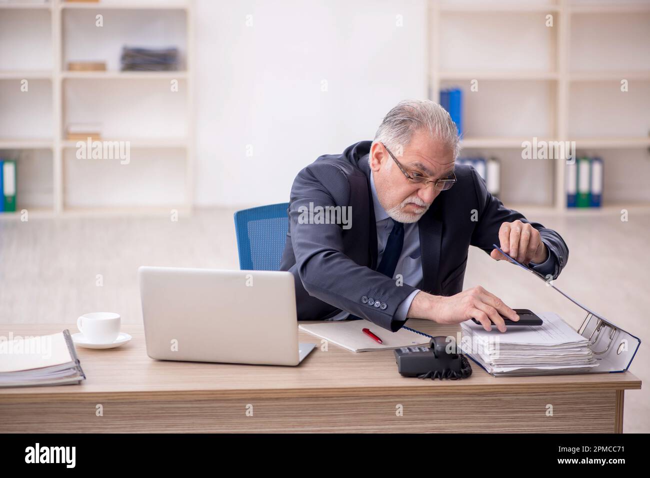 Old employee working at workplace Stock Photo - Alamy