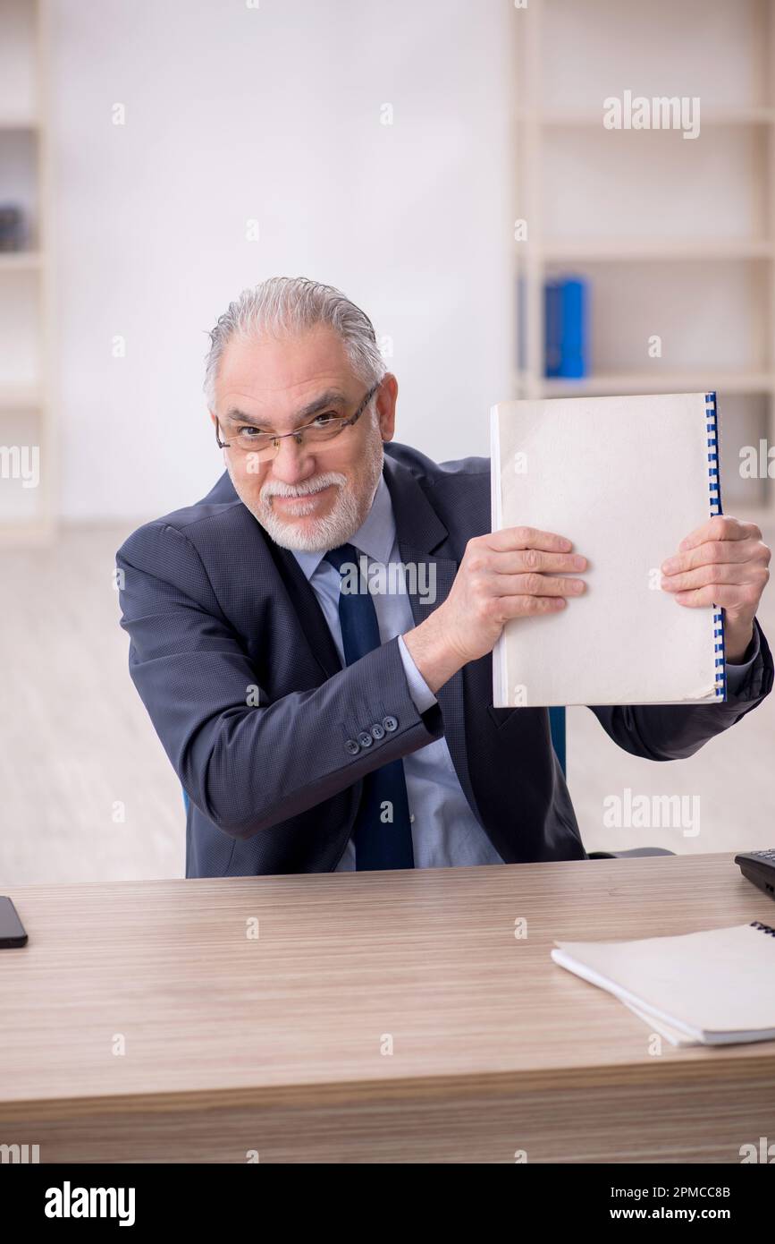 Old employee working at workplace Stock Photo - Alamy