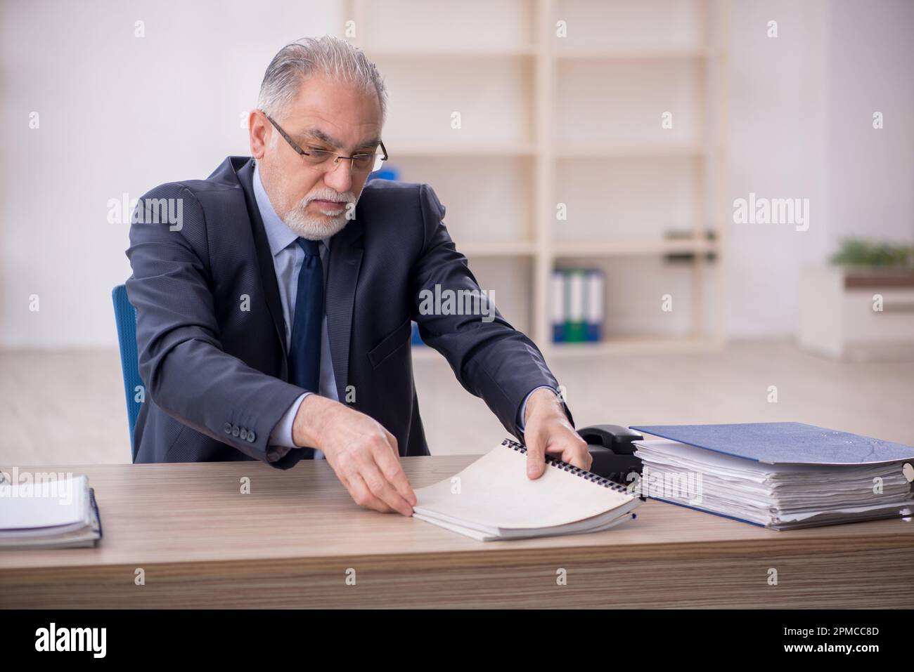 Old employee working at workplace Stock Photo - Alamy