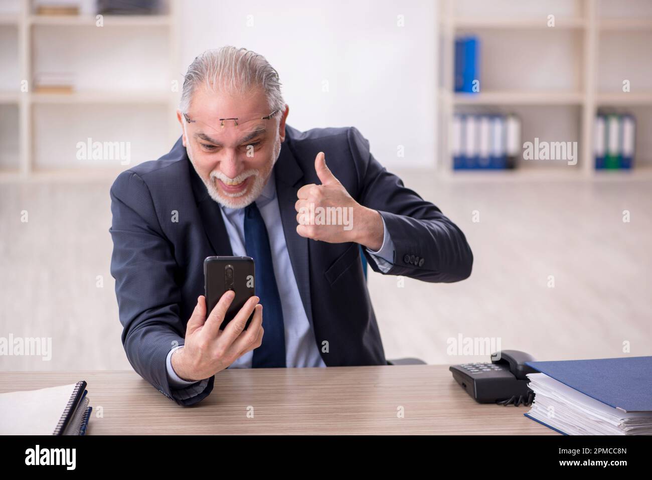 Old employee working at workplace Stock Photo - Alamy