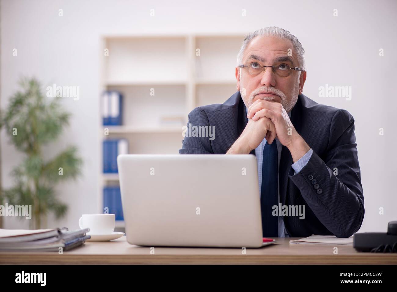 Old employee working at workplace Stock Photo - Alamy