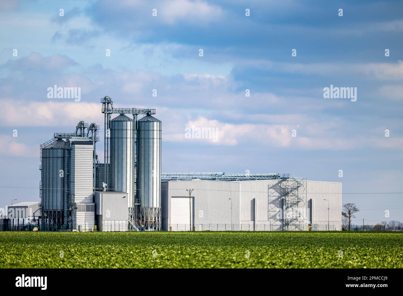 An animal feed production plant against the background of green ...