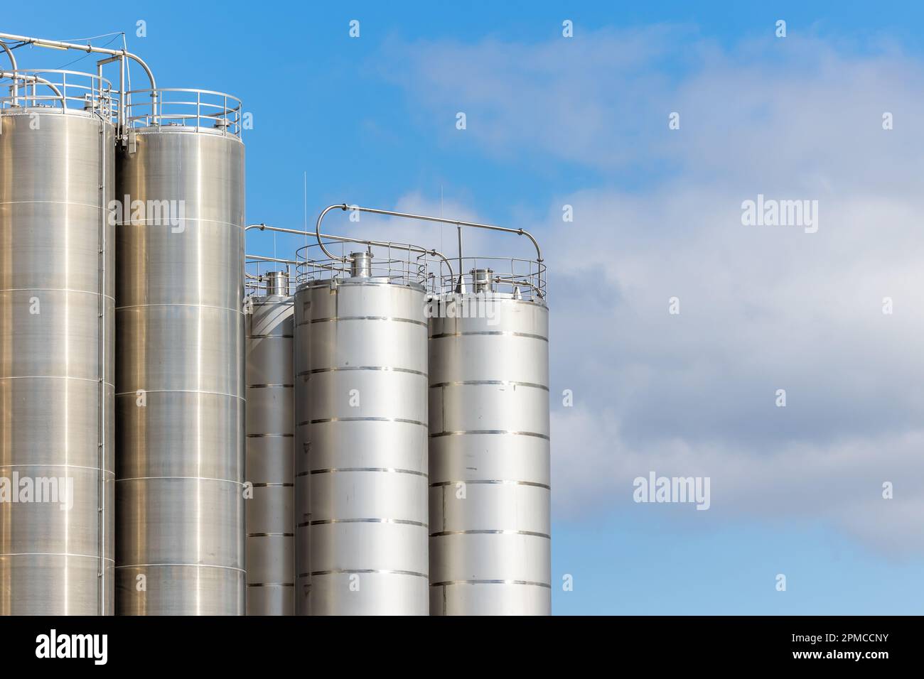 Stainless steel silos against the blue sky. Warehouses for storage of ...