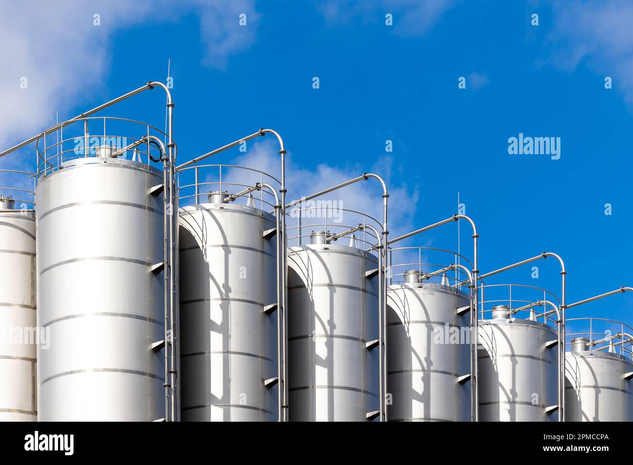 Stainless steel silos against the blue sky. Warehouses for storage of ...